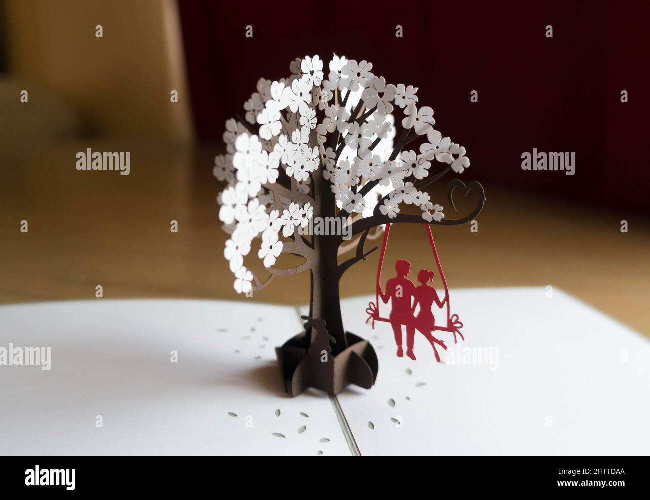 Closeup of an ornamental tree with a couple on a swing Stock Photo - Alamy