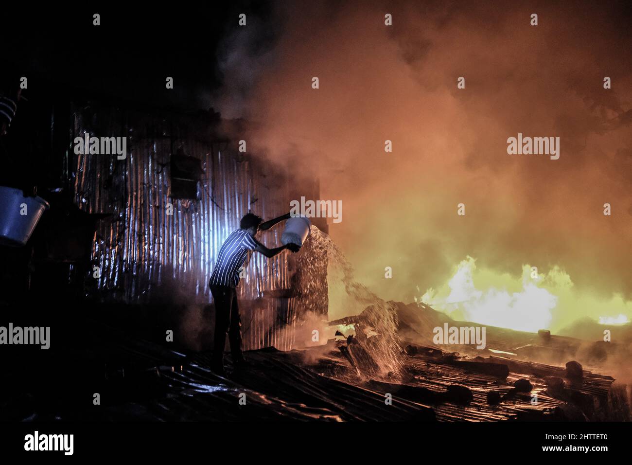 Nairobi, Kenya. 1st Mar, 2022. A man struggles to put out a night fire ...