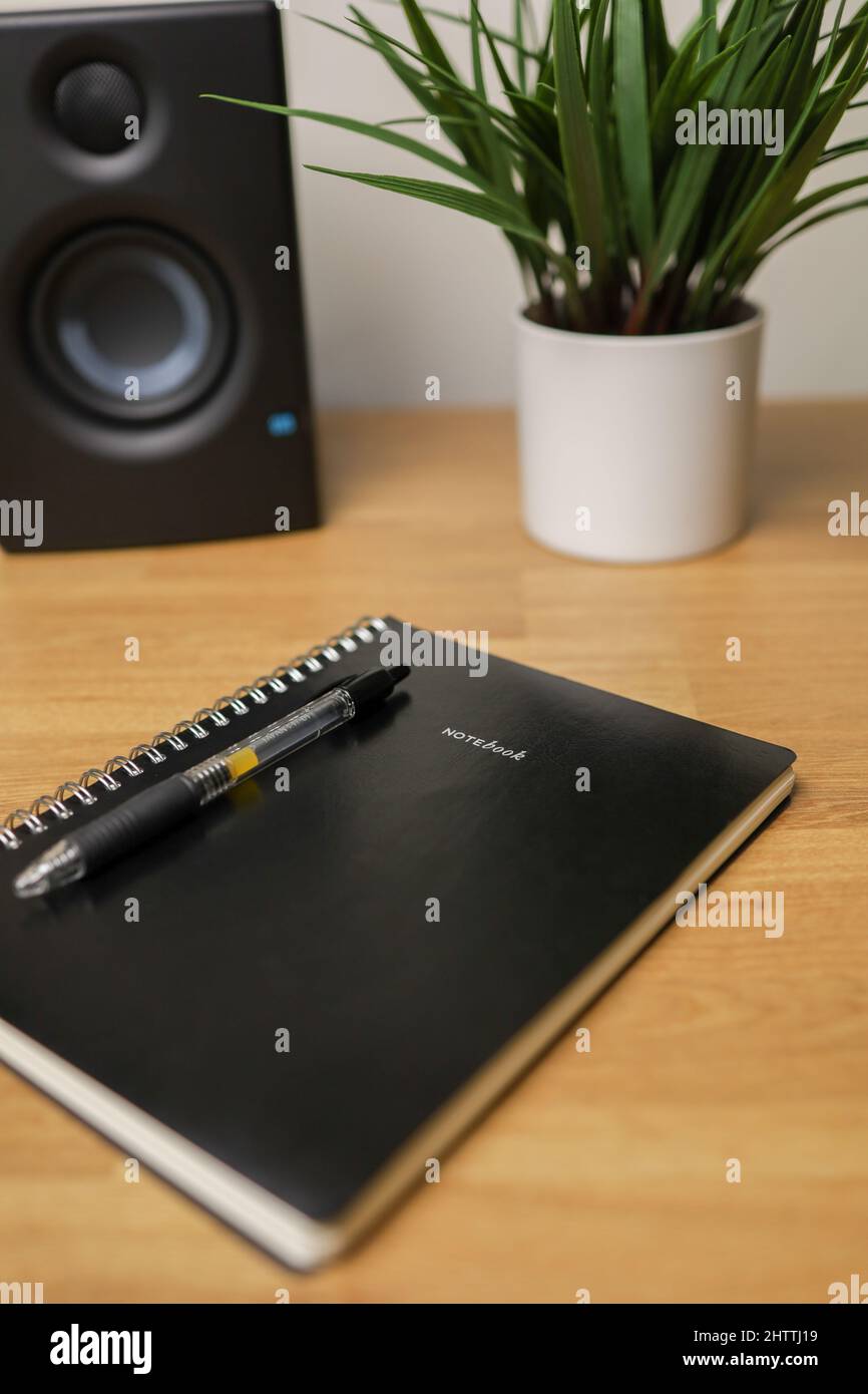 Vertical shot of a black notebook on desk Stock Photo - Alamy