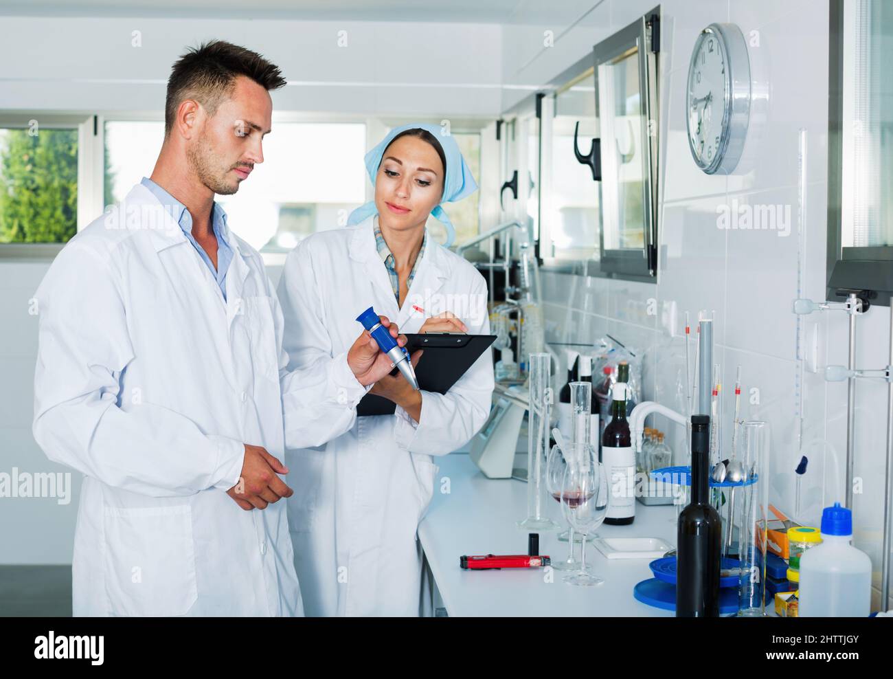 Two researchers in white coat checking wine acidity in laboratory Stock ...