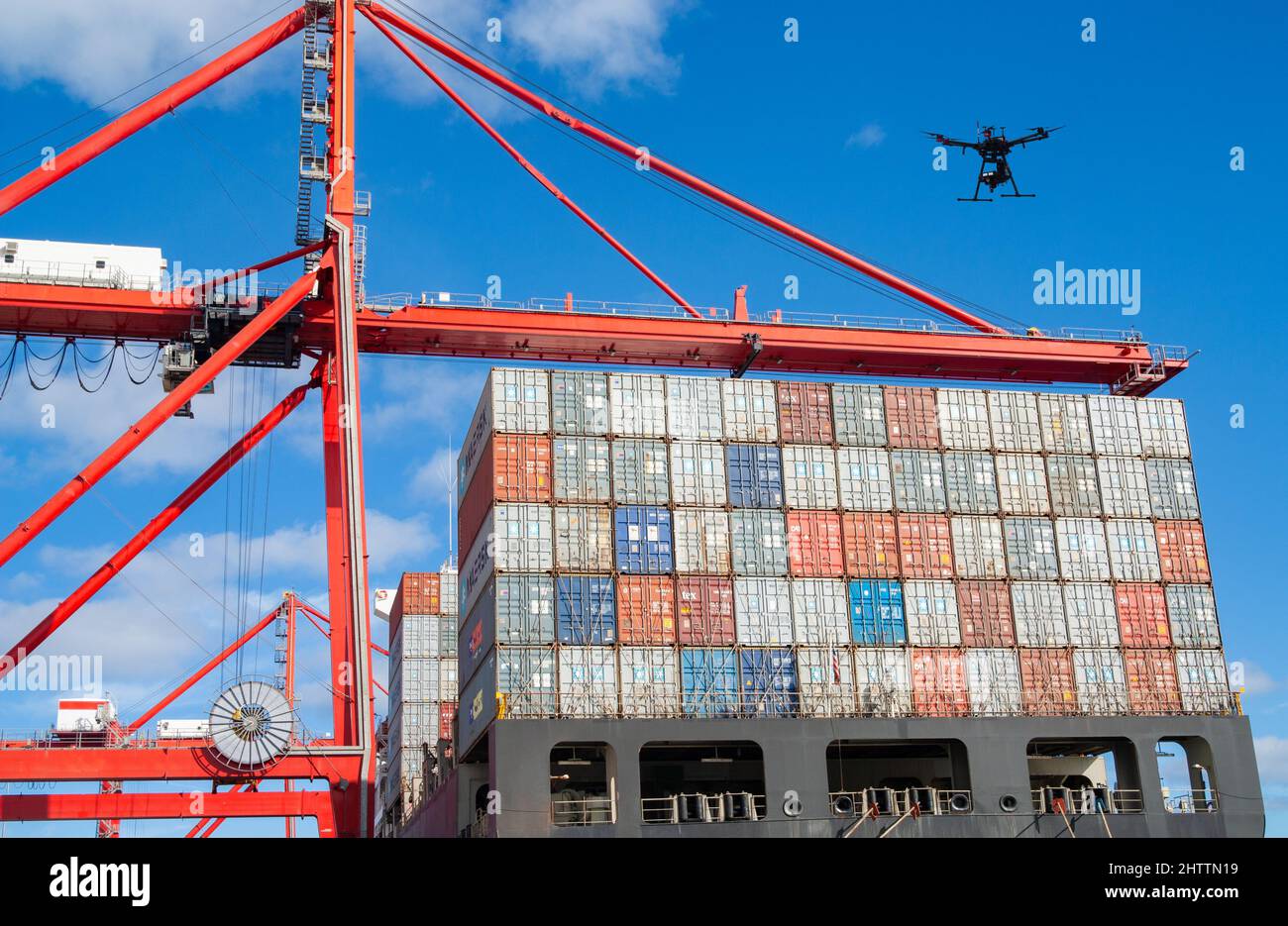 Drone flying above shipping containers on ship in port. Concept: drone ...