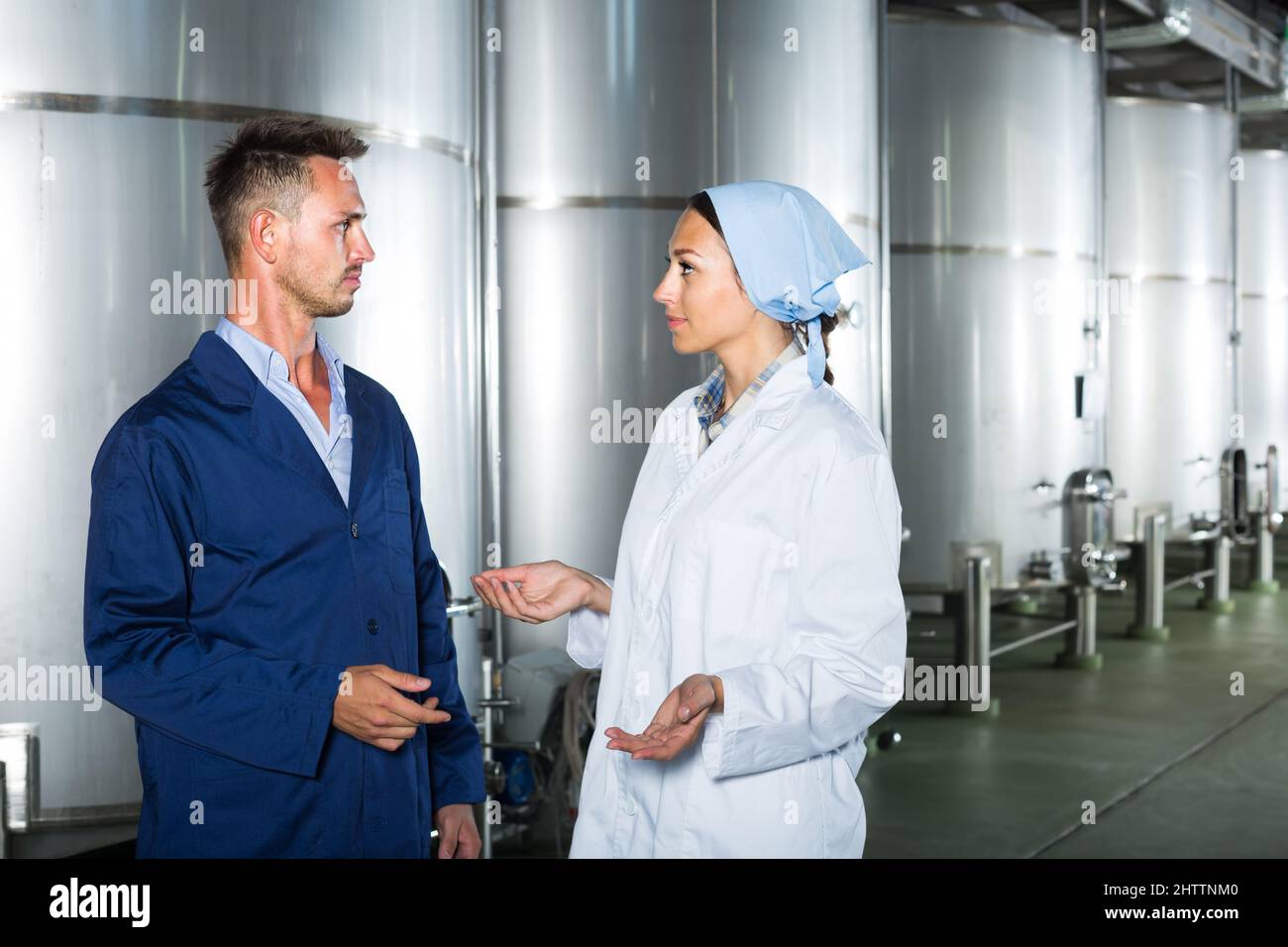 Two young winery workers in uniform Stock Photo - Alamy