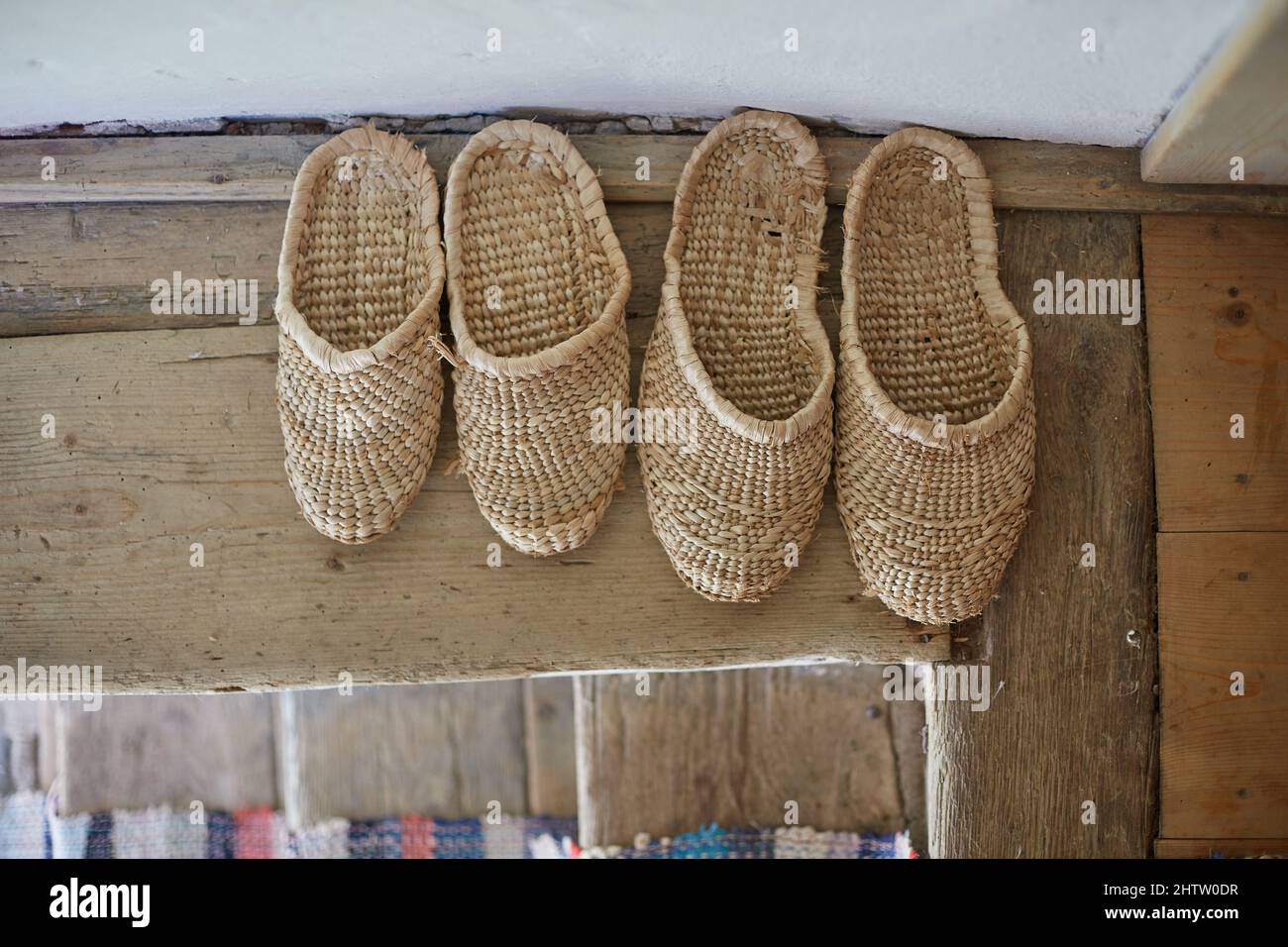 Top view of wicker flip-flops on the floor at the entrance of an old ...