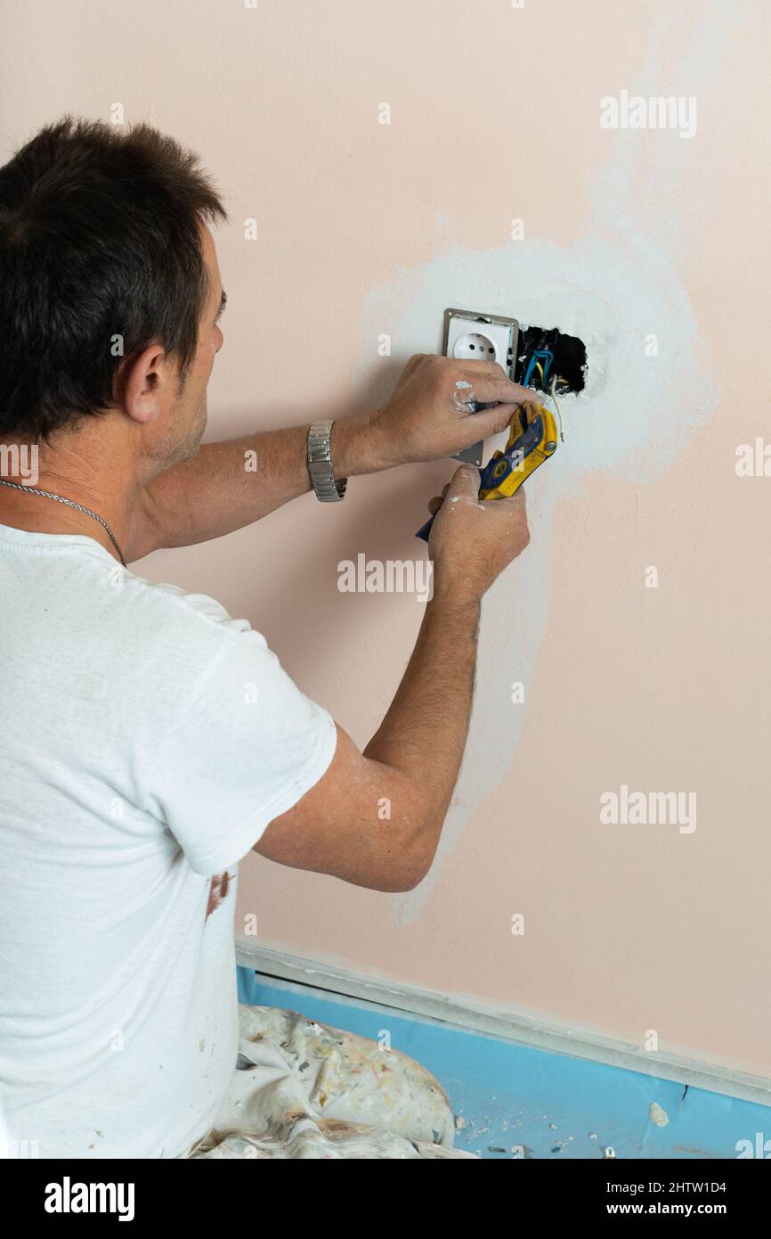 Electrician working on an electrical installation on the wall Stock ...