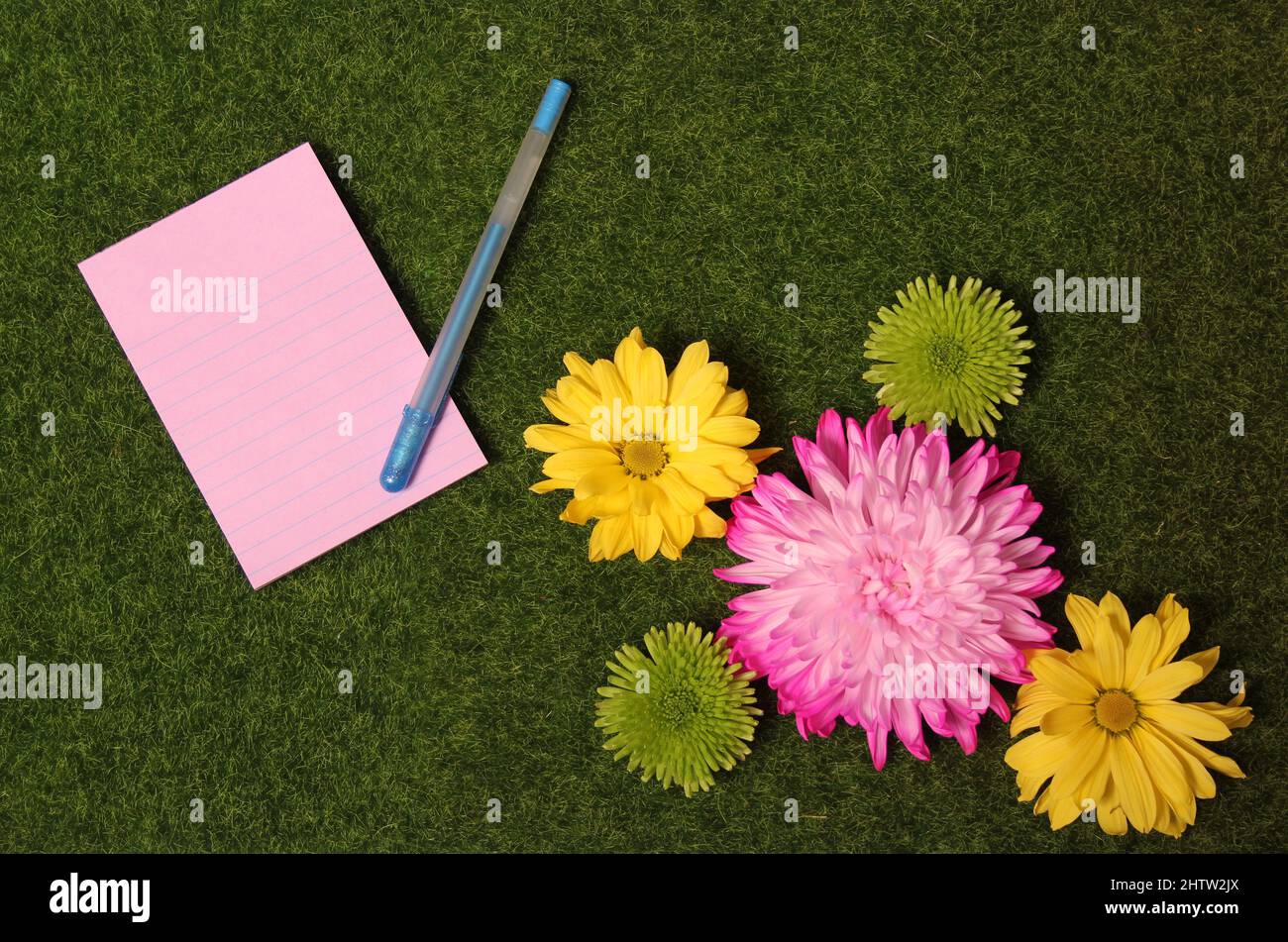 Blank Note paper on Artificial Green Grass Background With Colorful ...