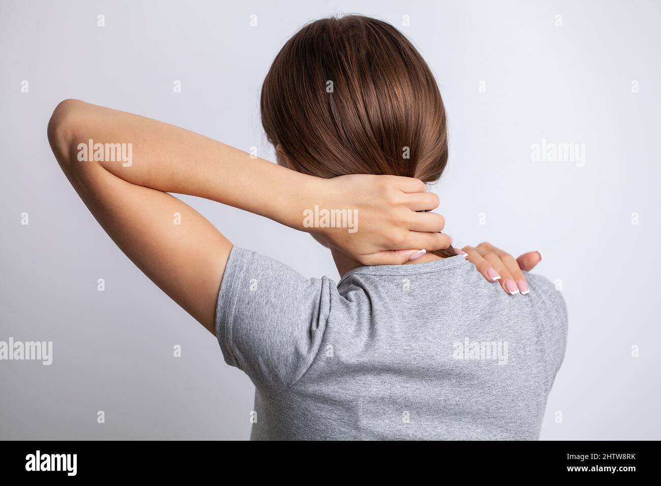 Sick woman suffering from sore neck on gray background Stock Photo - Alamy