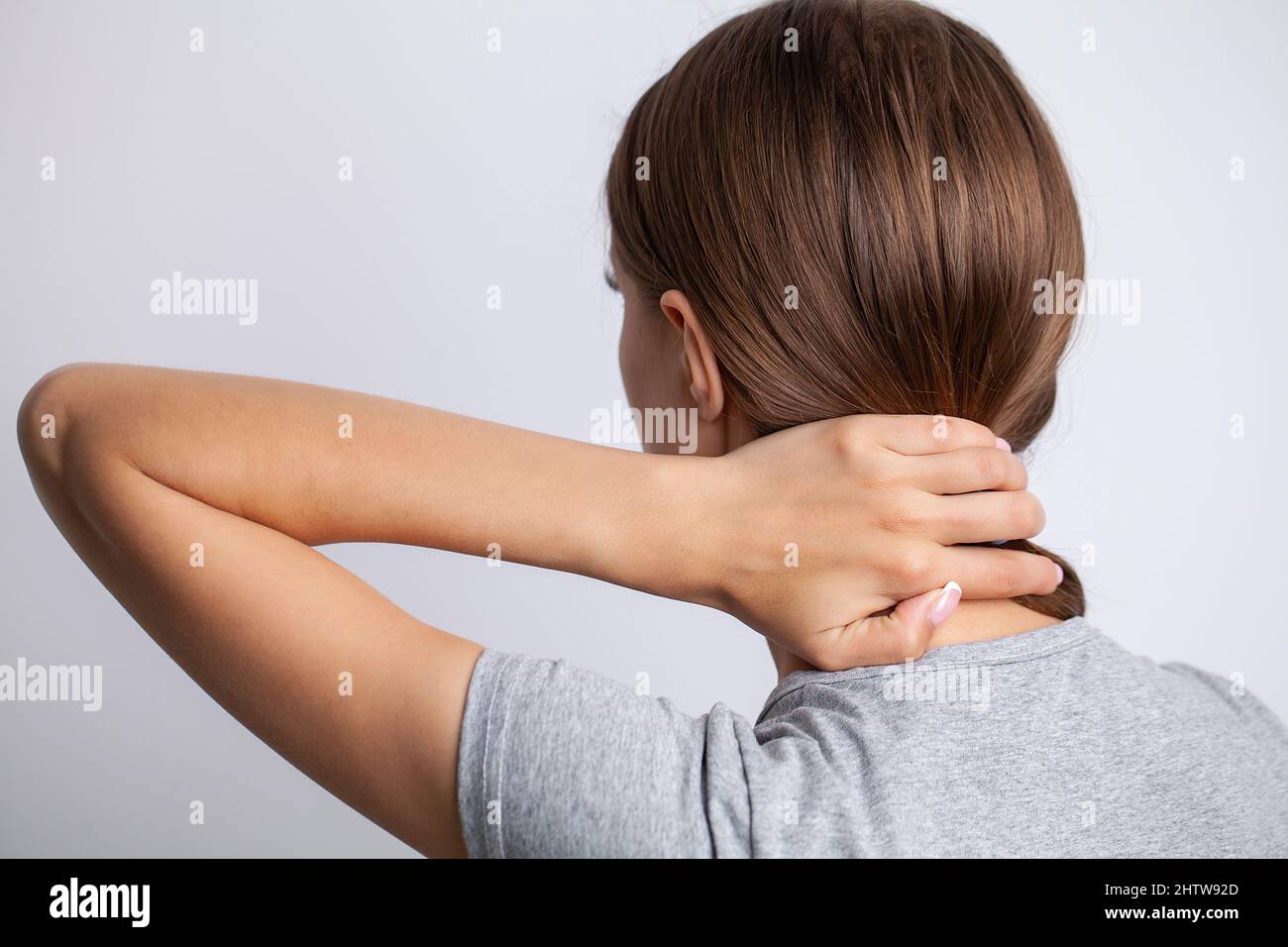 Sick woman suffering from sore neck on gray background Stock Photo - Alamy