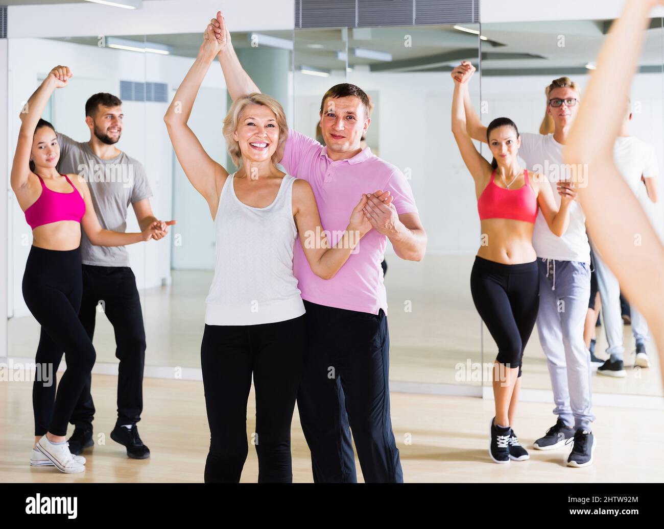 sporty girls and men learning salsa steps Stock Photo - Alamy