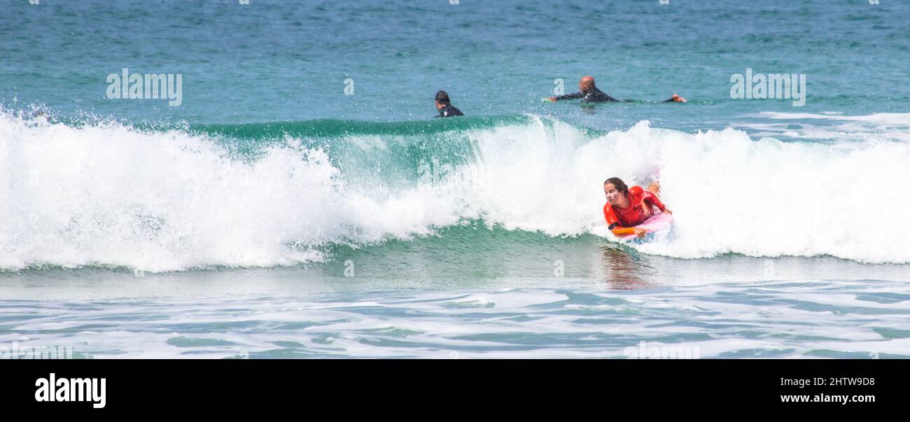 The woman trying to stand up on the surfboard to catch the wave Stock ...
