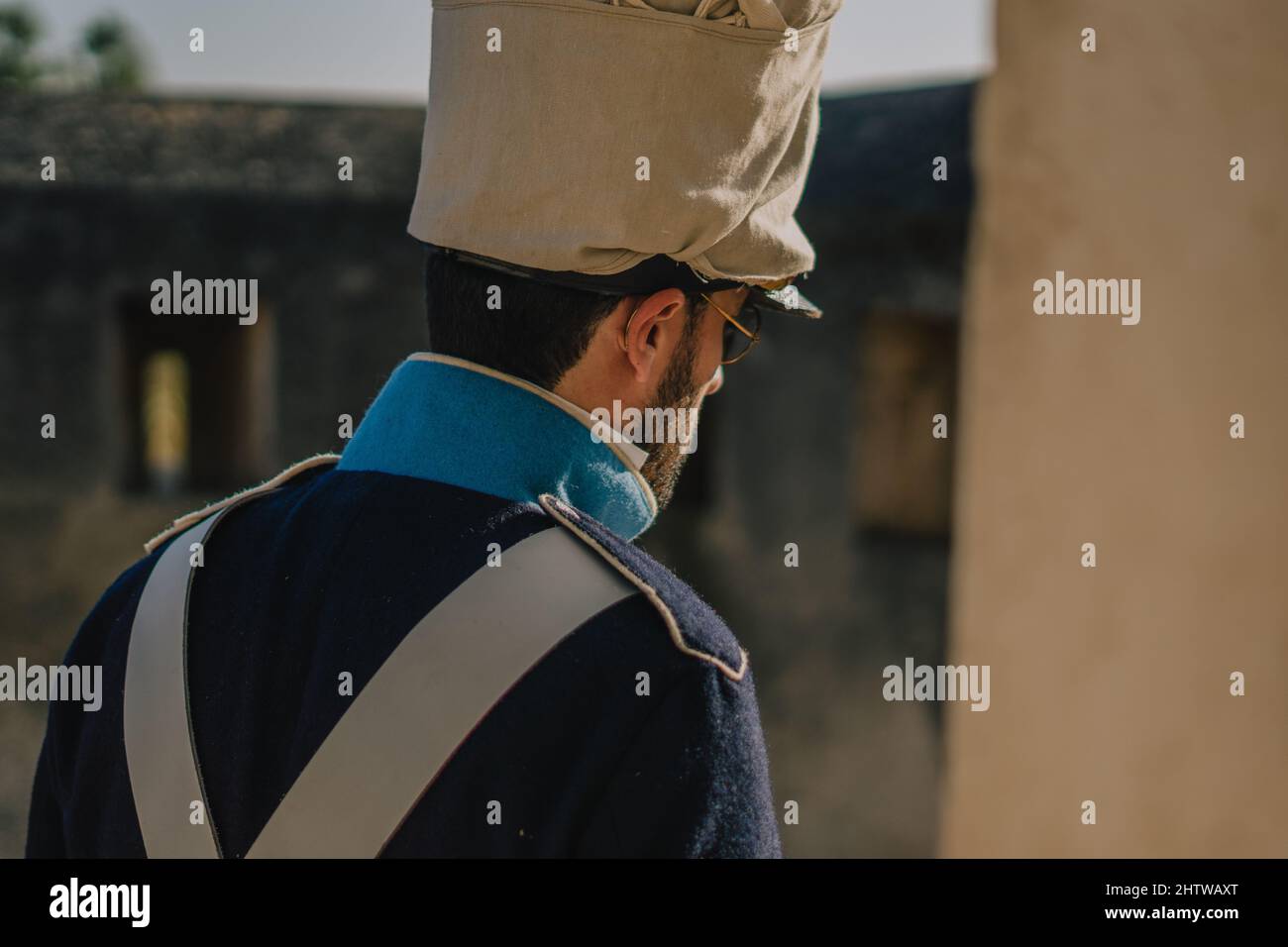Rear view of a male military officer wearing uniform with big brown hat ...
