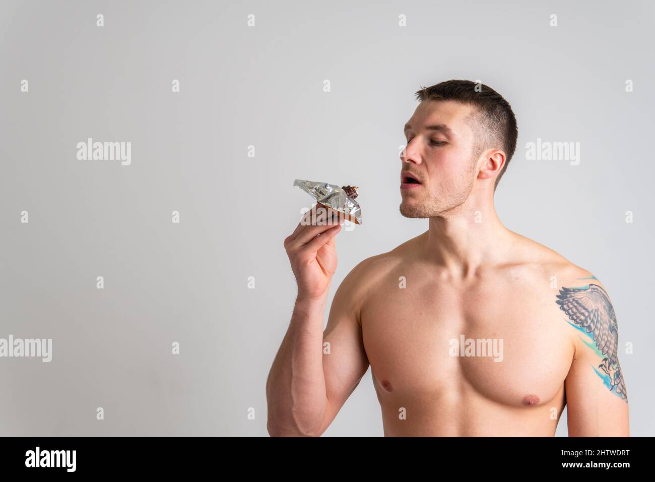 Man eats protein bar on white background isolated protein eat, holding ...