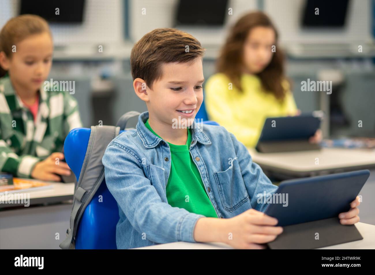 Boy looking at tablet at school lesson Stock Photo - Alamy