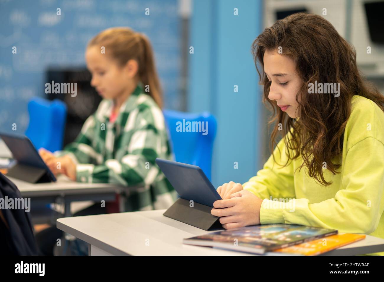 Girls sitting and looking at tablets Stock Photo - Alamy