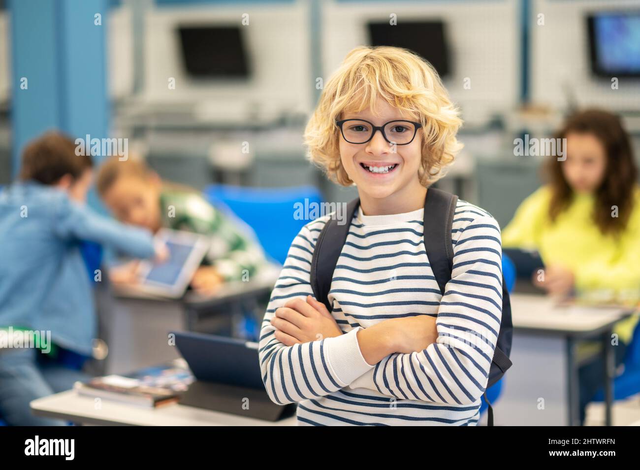 Boy standing in class looking at camera Stock Photo - Alamy