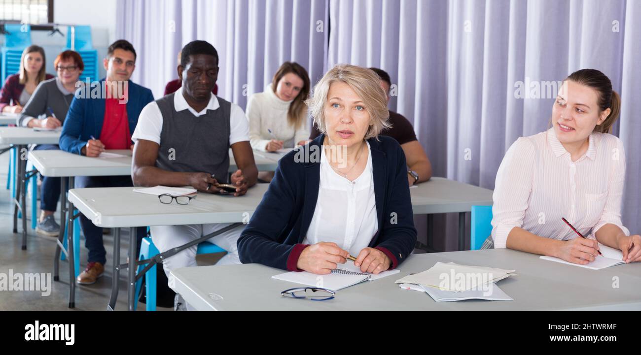 Adult students listening in classroom Stock Photo - Alamy