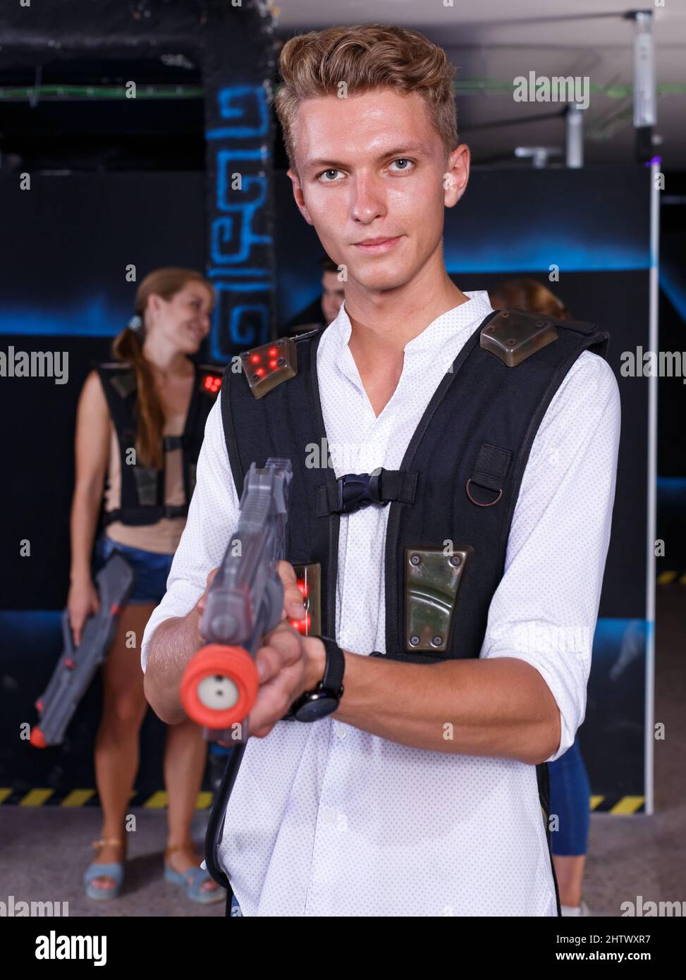 Positive guy with laser pistol during playing laser tag with his ...