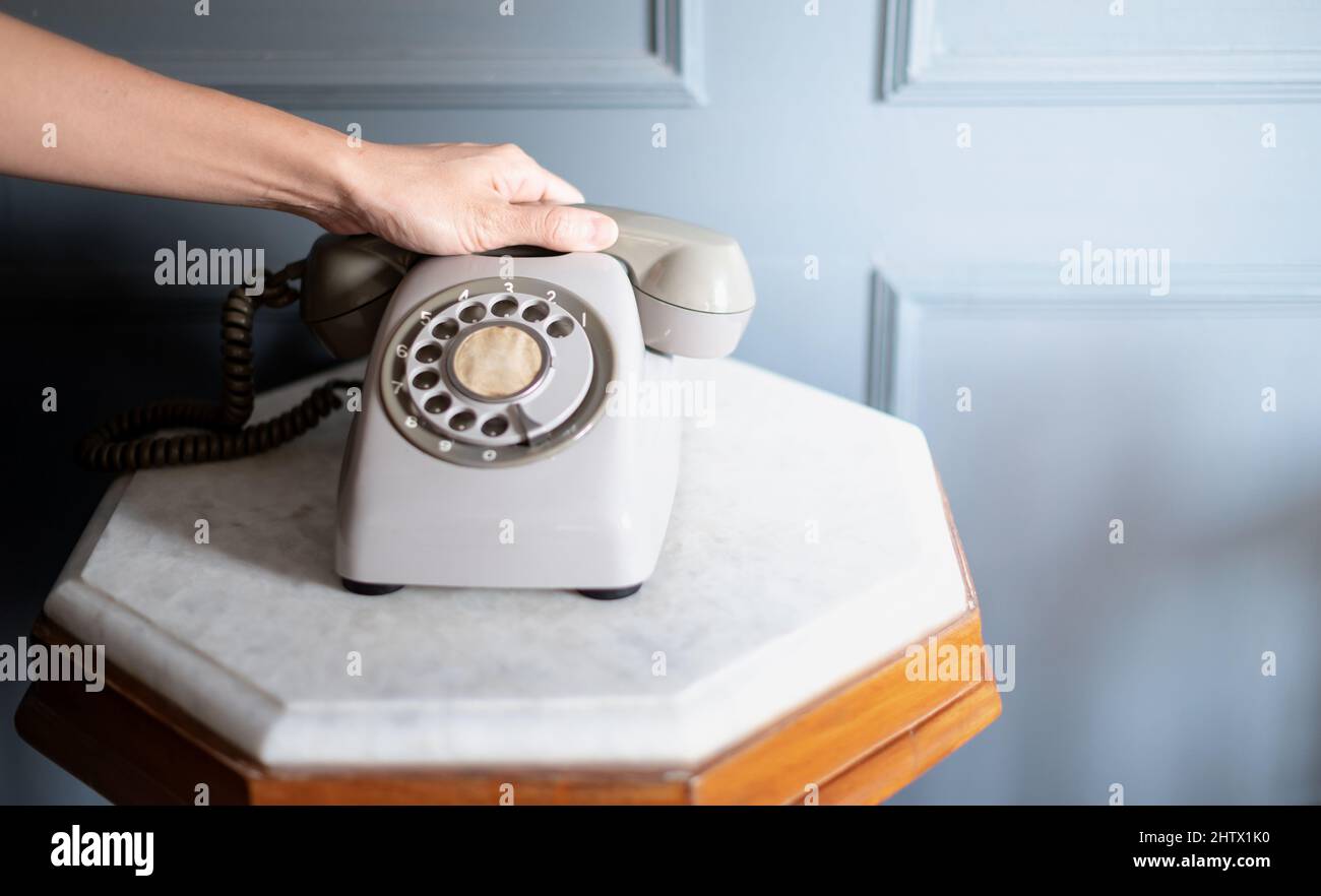 Female hand hold The old grey telephone set of the 70s of the 20th ...
