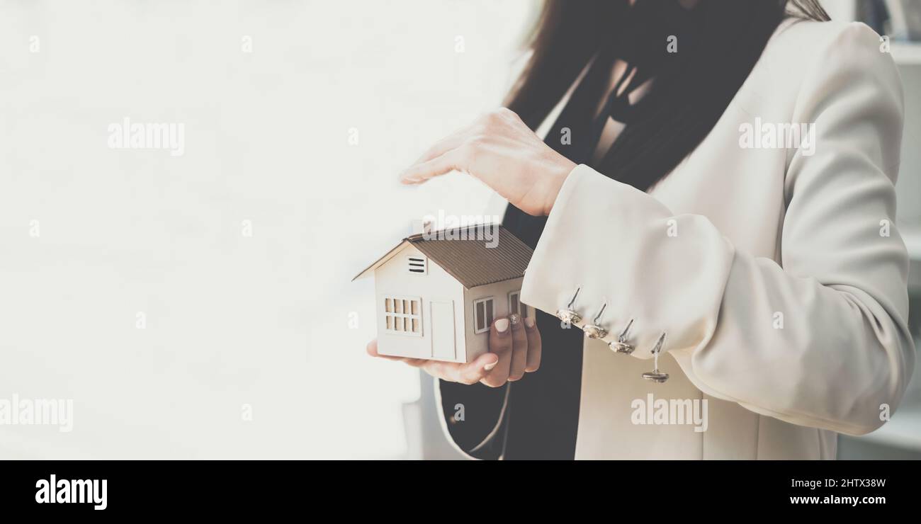 A woman holding and checking house model .Real Estate House Appraisal ...