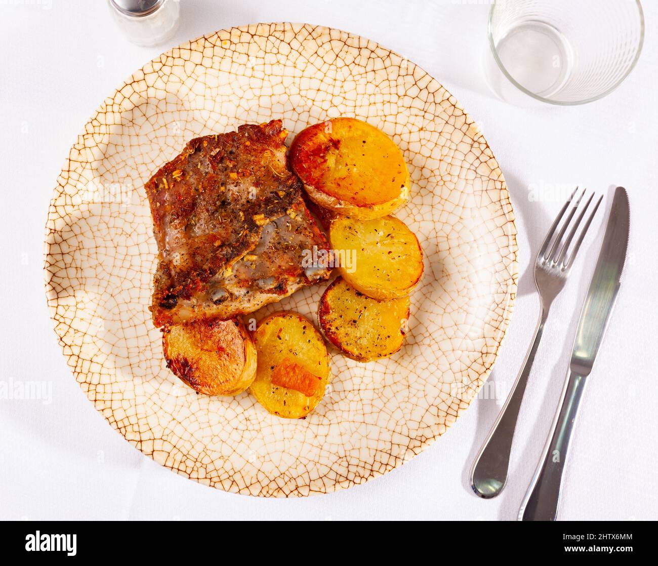 Baked pork ribs with vegetable garnish of fried potatoes Stock Photo ...