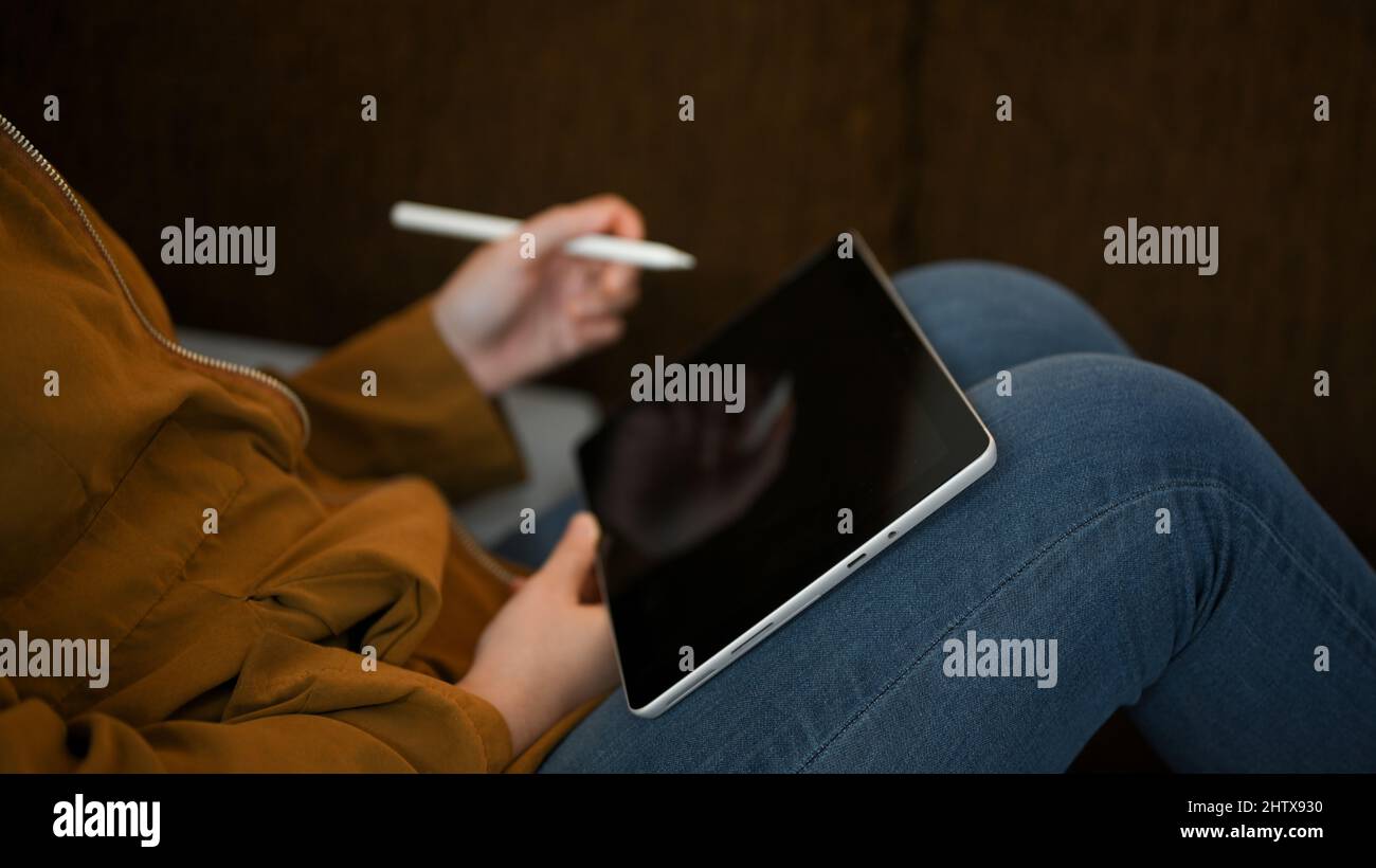 Side view, Female freelancer using a smart digital tablet touchpad in ...