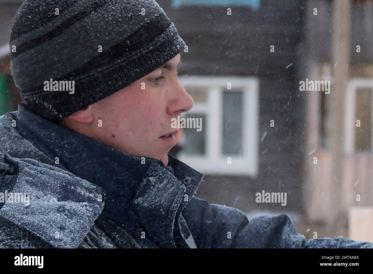 Portrait of a worker in a blue hooded jacket in profile at the ...