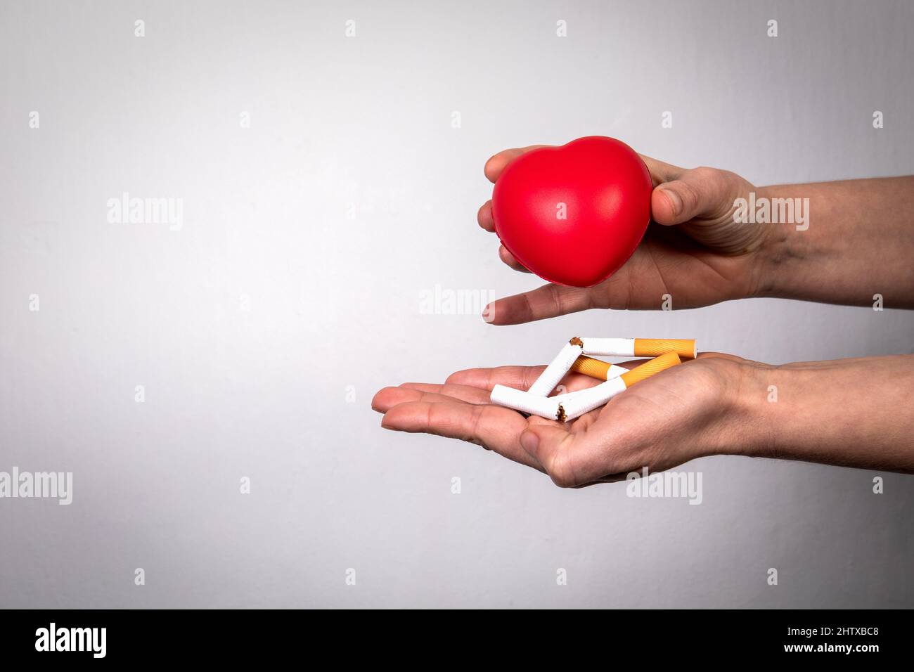 Cardiovascular disease and health concept. Cigarettes and a red rubber ...