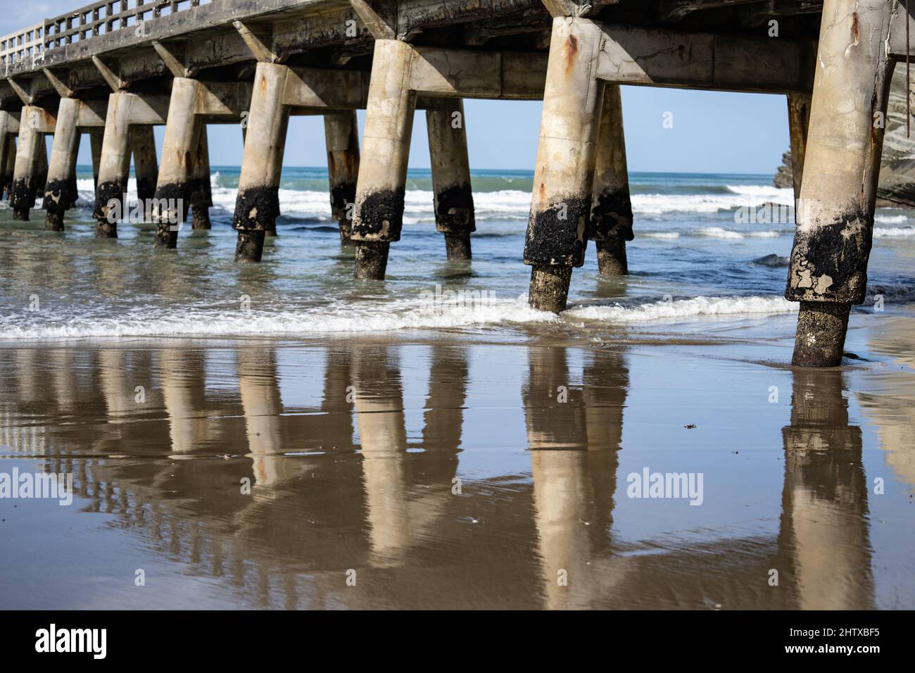 Long repeating structural pattern,reflection in wet sand and ...