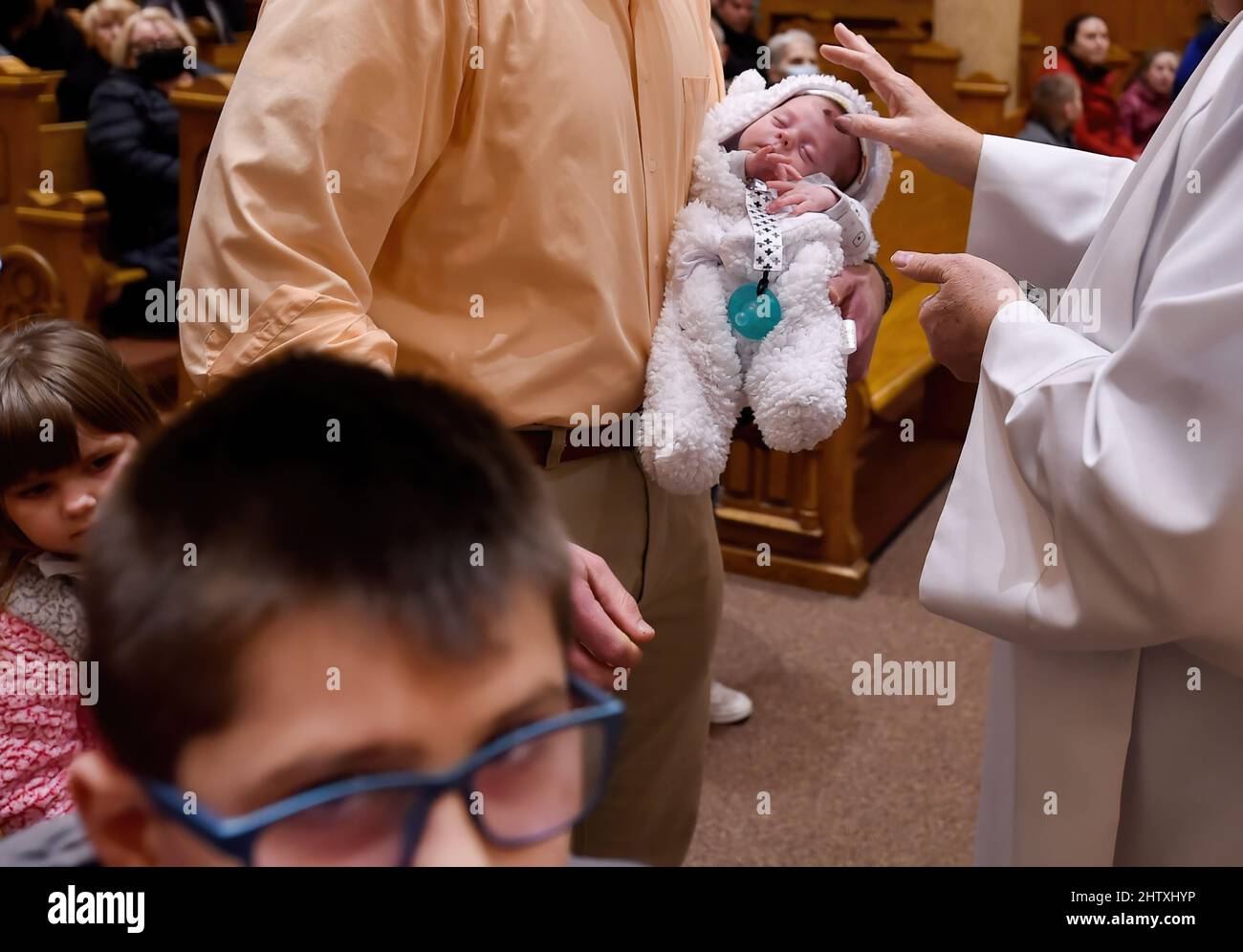 A priest seen applying ash on a kid's forehead at Saints Peter and Paul ...