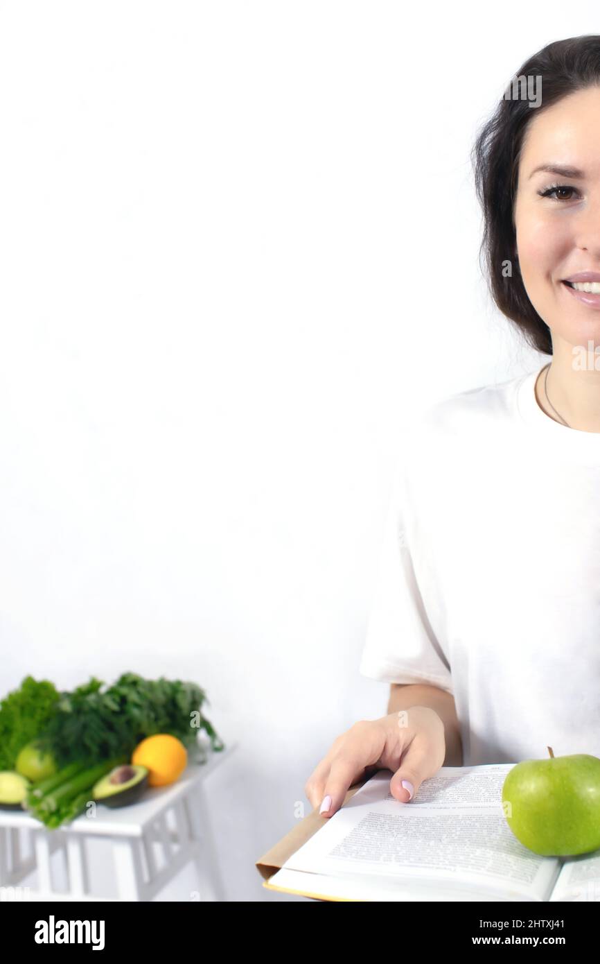 The concept of studying proper nutrition. Woman with a book, an apple ...