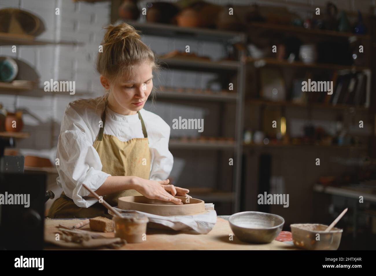 Girl make clay plate in ceramic workshop Stock Photo - Alamy
