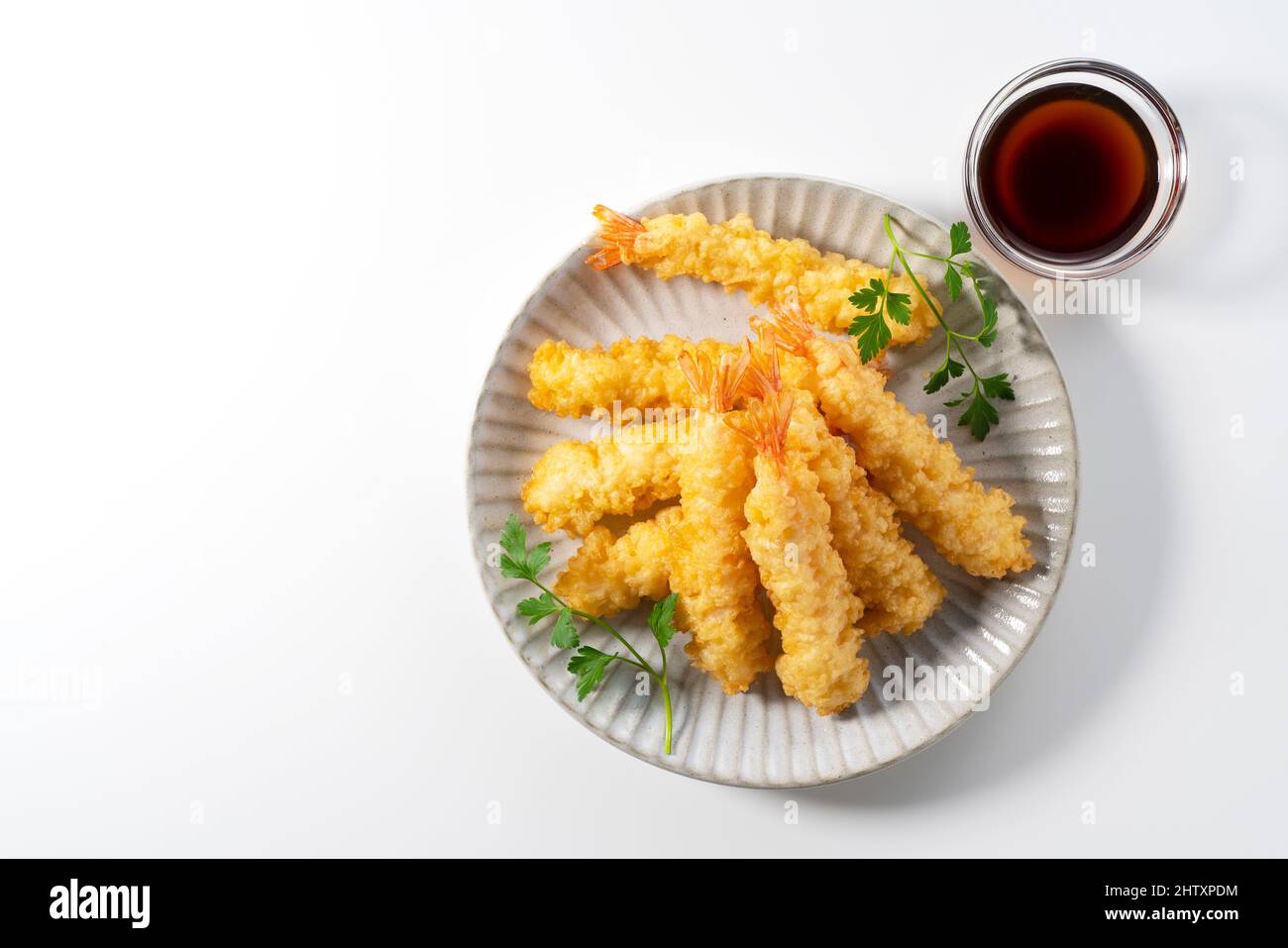 Shrimp tempura on a plate placed on a white background. Tempura is a ...