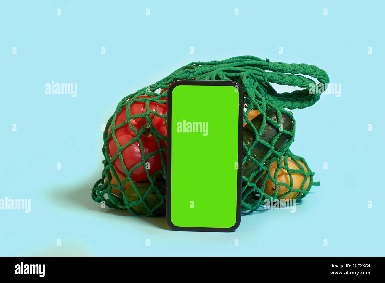 Online shopping. A smartphone with a green screen and vegetables in a ...