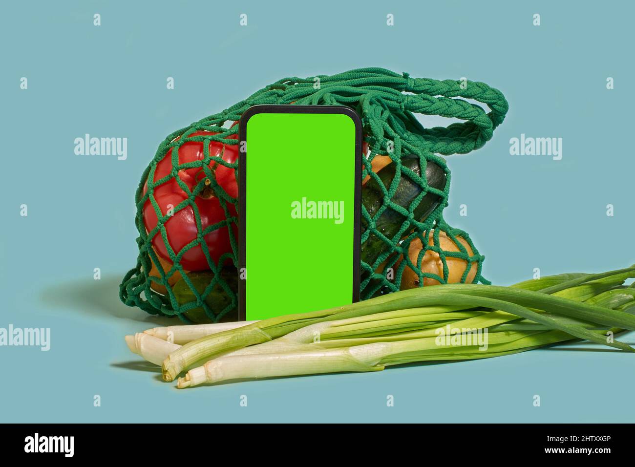 Online shopping. A smartphone with a green screen and vegetables in a ...