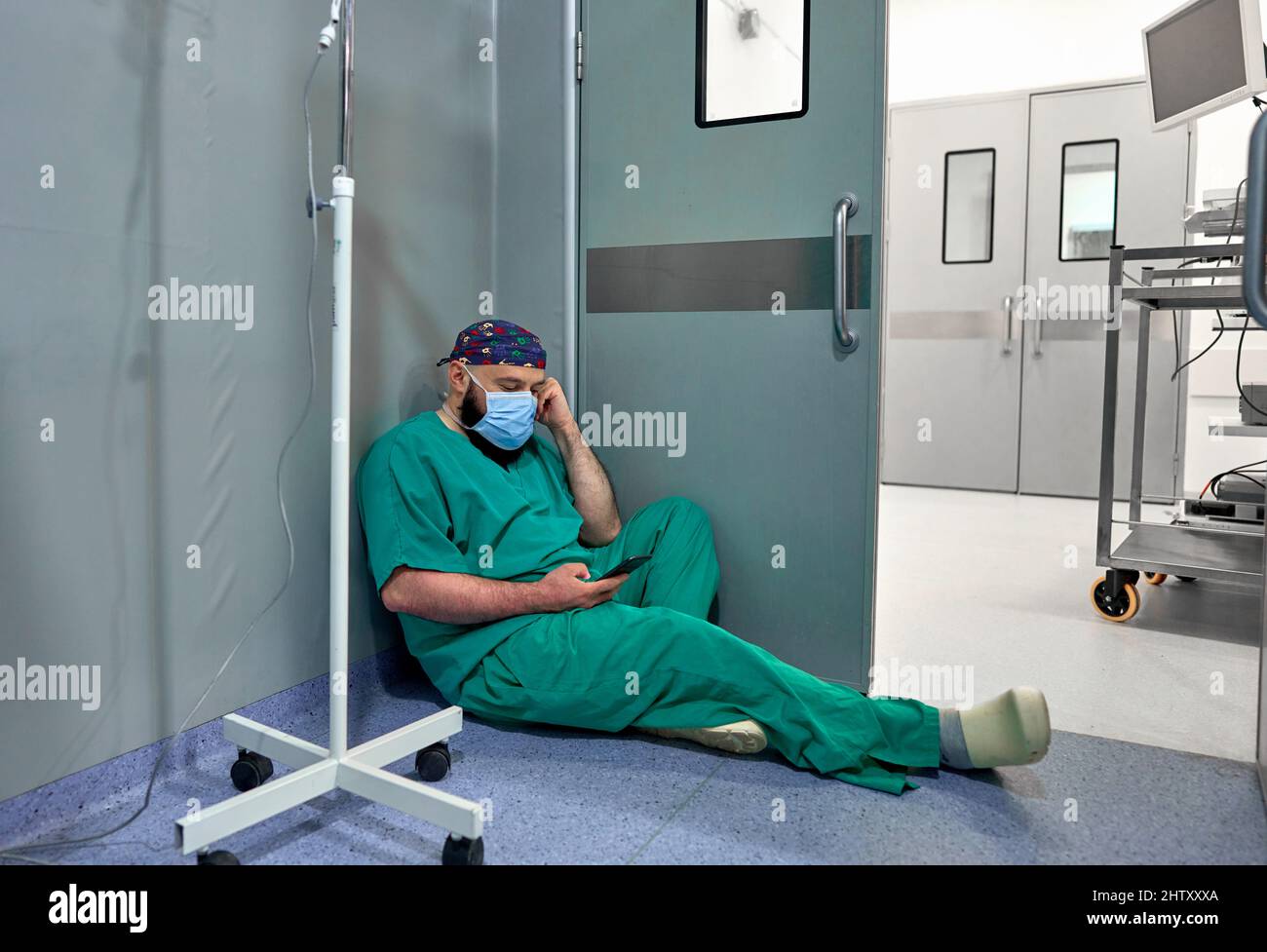 doctor tired after the operation is sitting on the floor Stock Photo ...