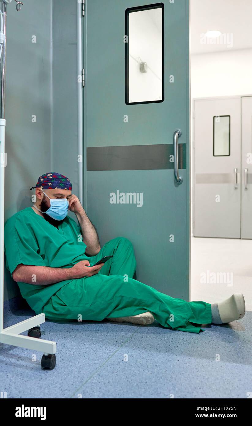 doctor tired after the operation is sitting on the floor Stock Photo ...