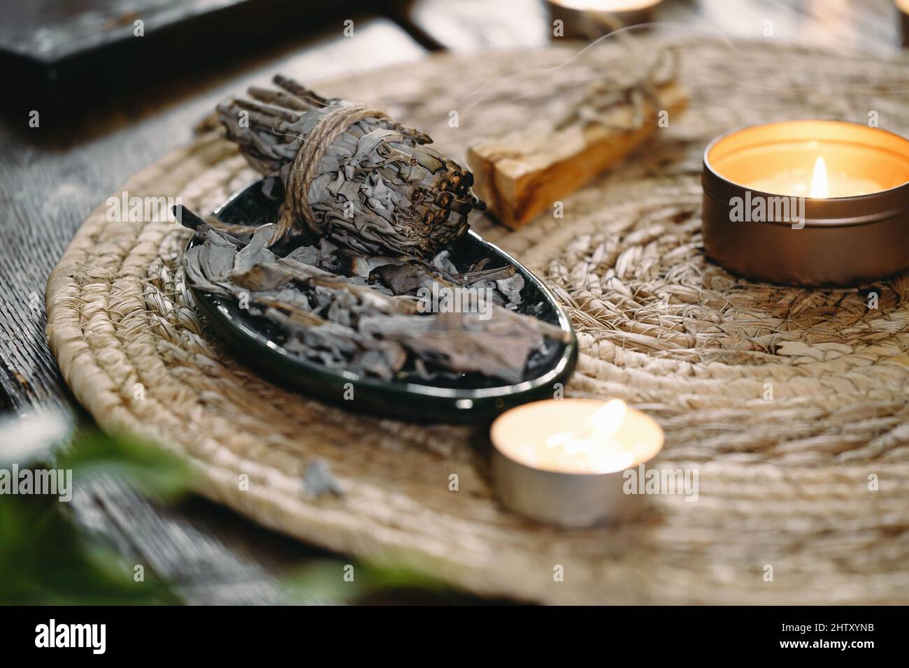 Woman hands burning white sage, before ritual on the table with candles ...
