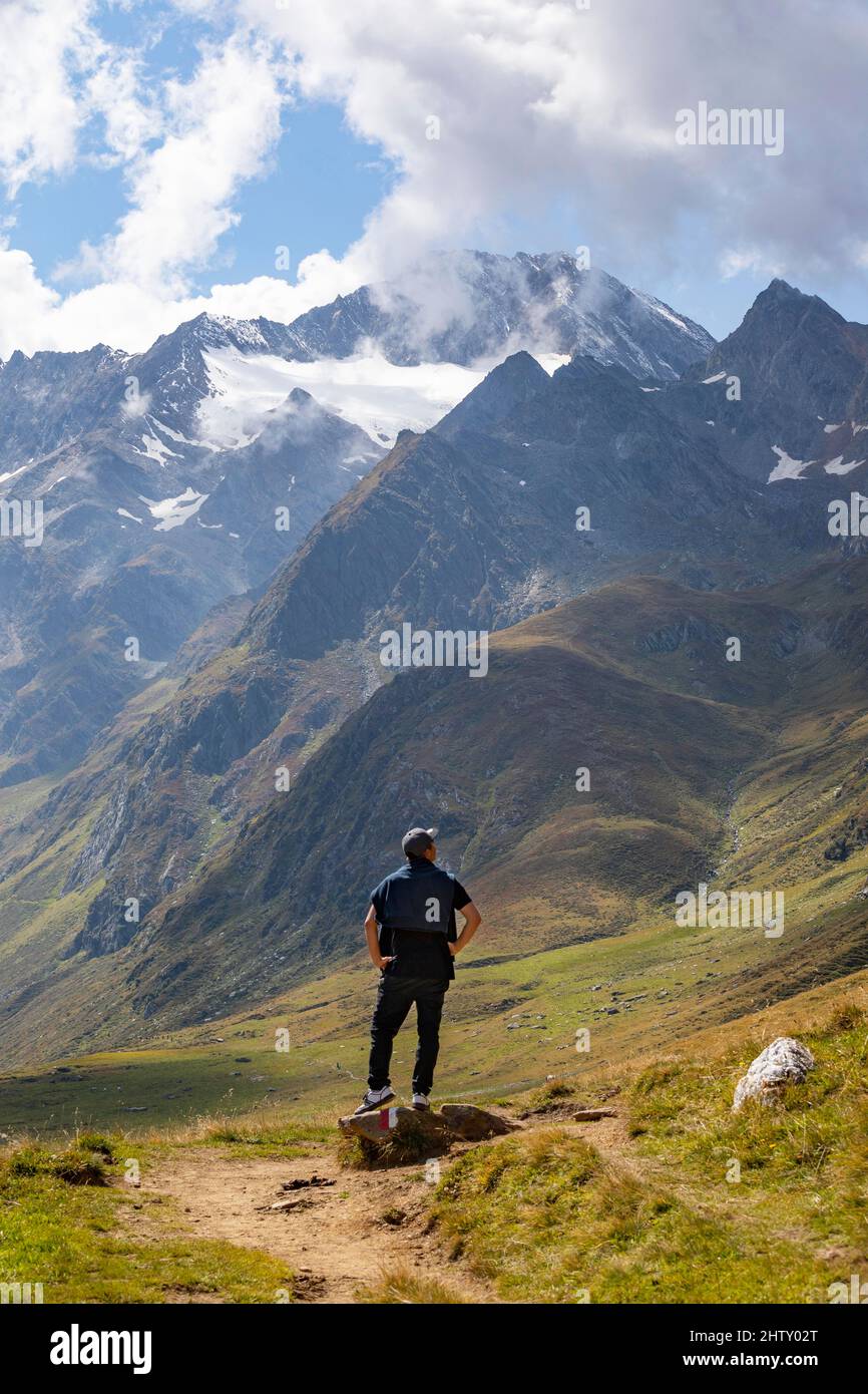 Hiker looking into the mountain massif of the Oetztal Alps in the rear ...