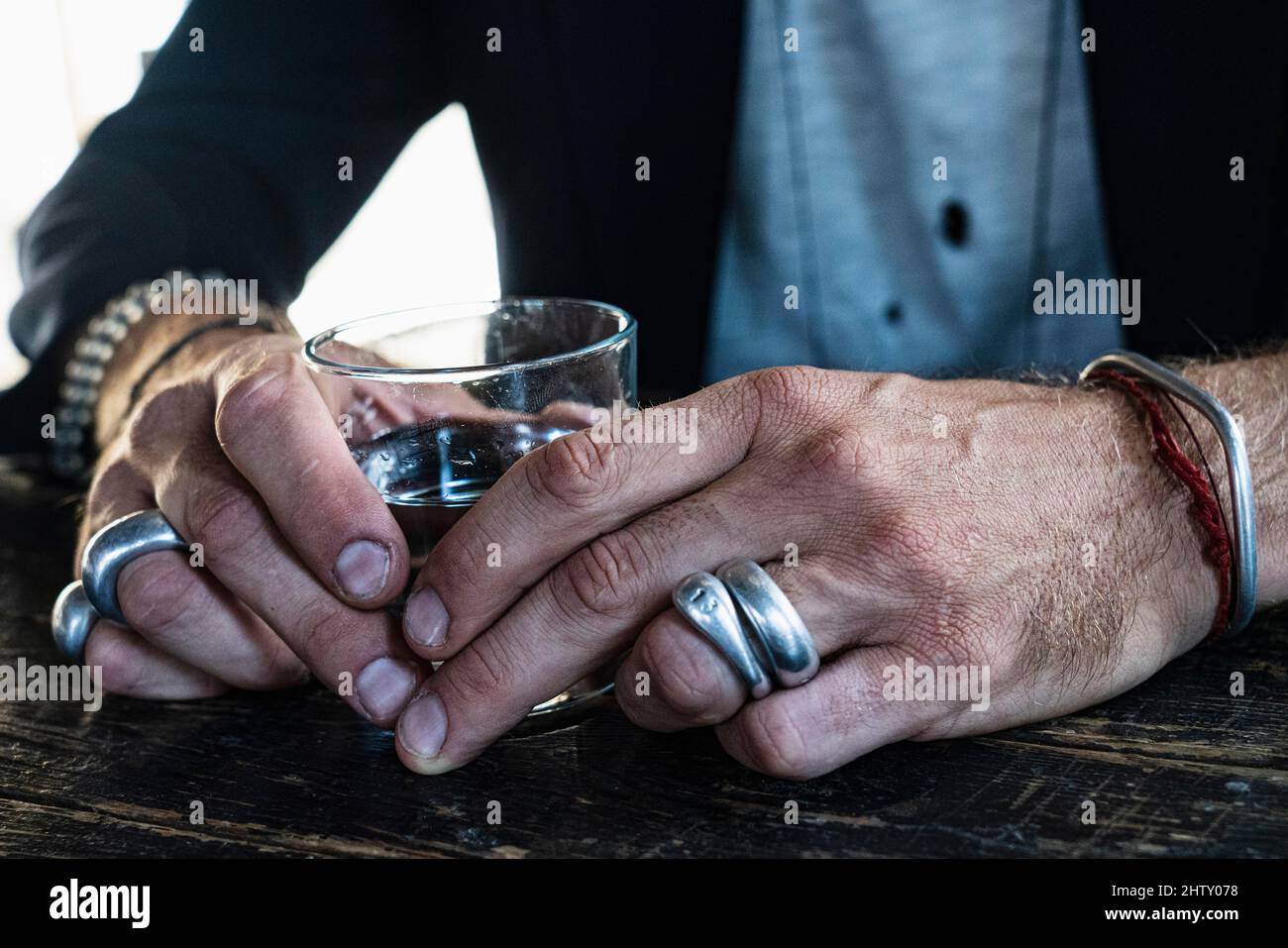 Men's hands with silver jewellery at a bar Stock Photo - Alamy