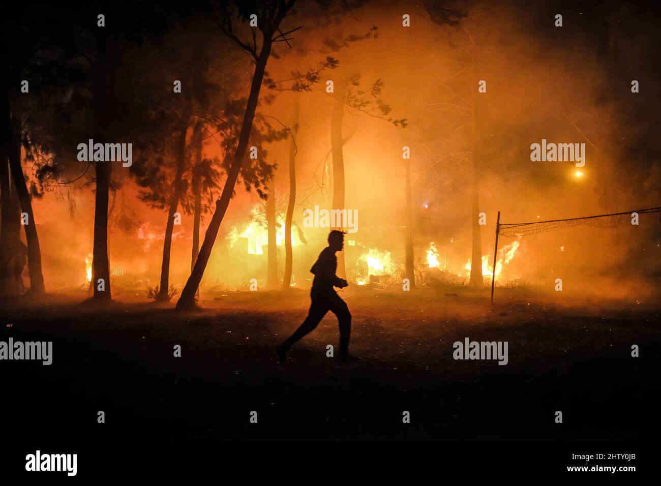 Nairobi, Kenya. 01st Mar, 2022. A man runs past a burning forest to ...