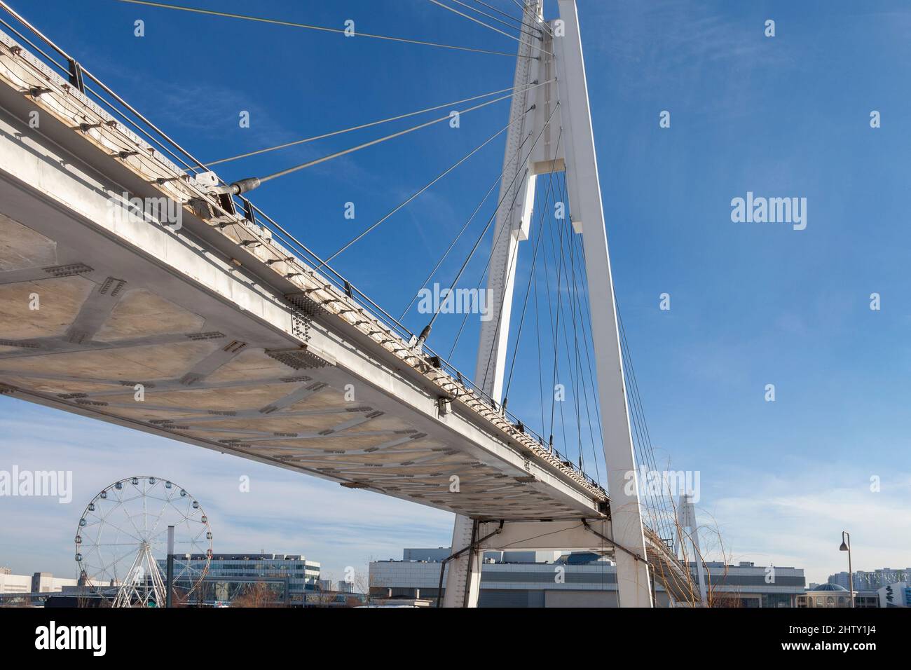 Modern pedestrian bridge against the blue sky. Bottom view Stock Photo ...