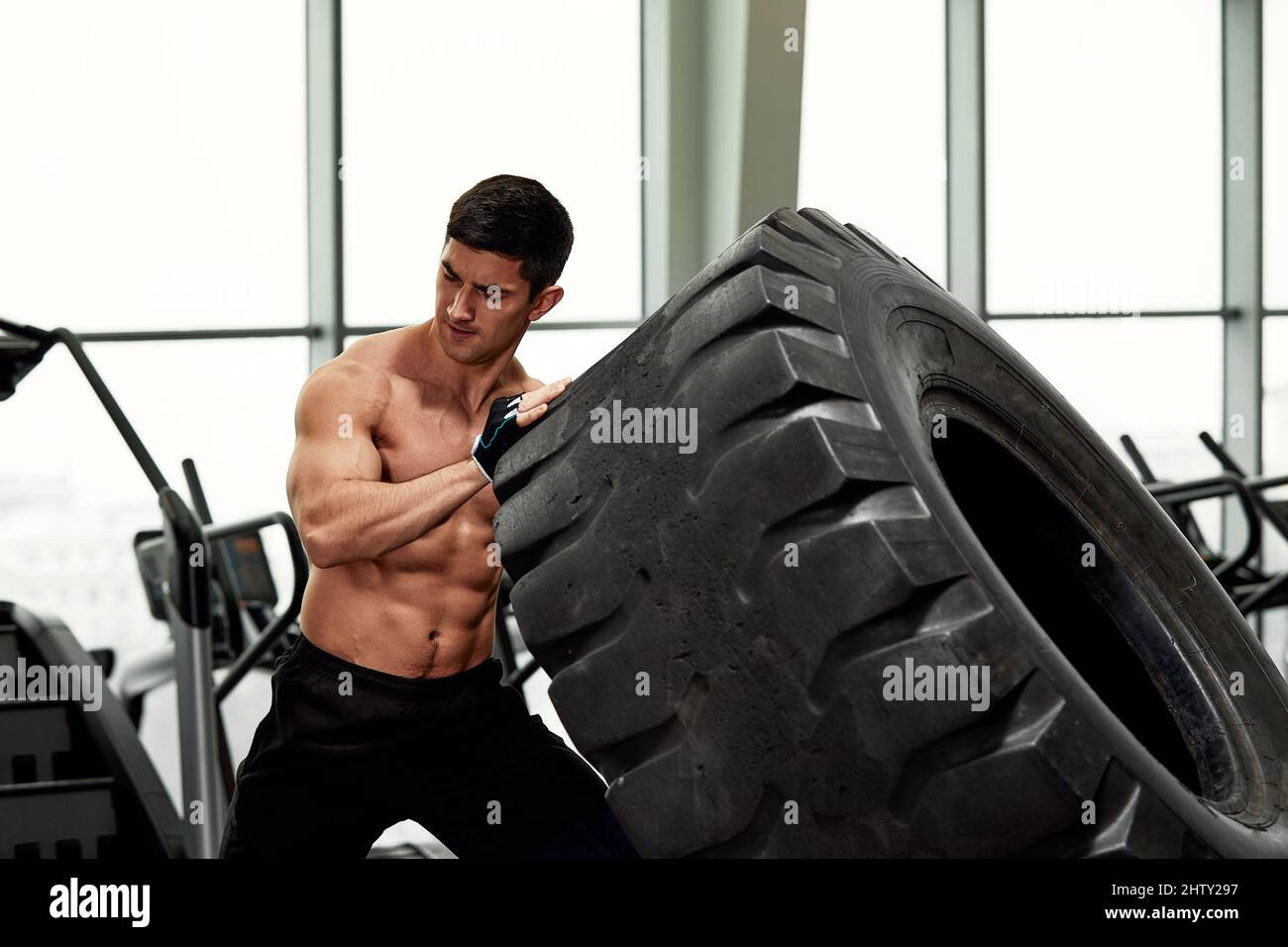 Muscular fitness man flipping tire wheel. Concept functional training ...
