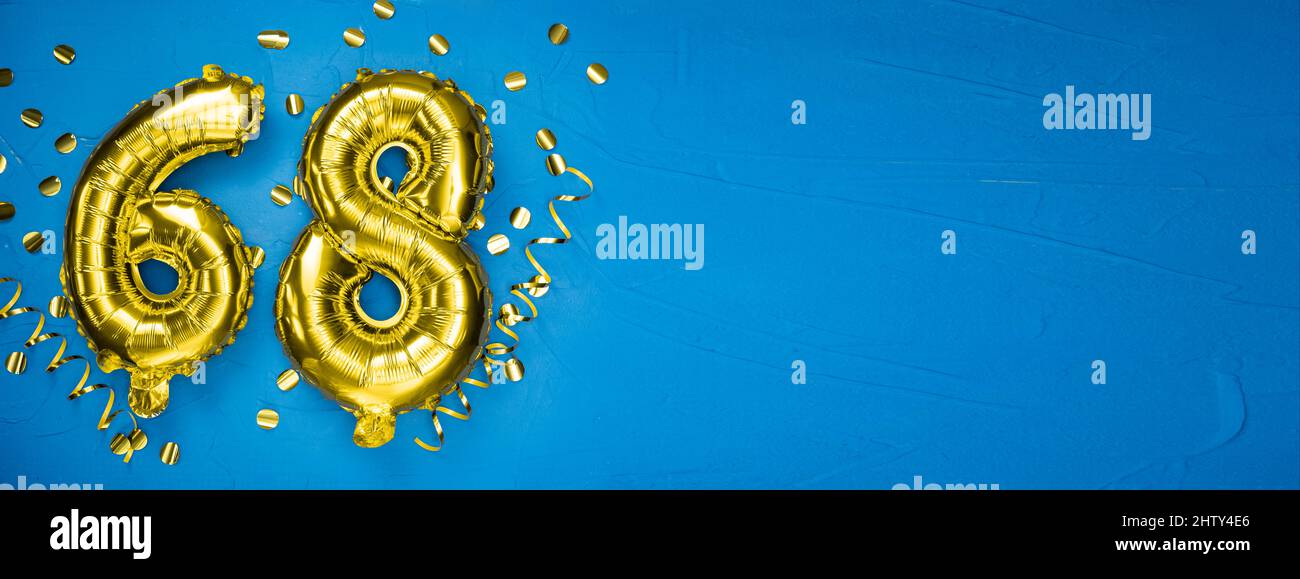 number sixty eight golden yellow foil balloon on blue concrete ...