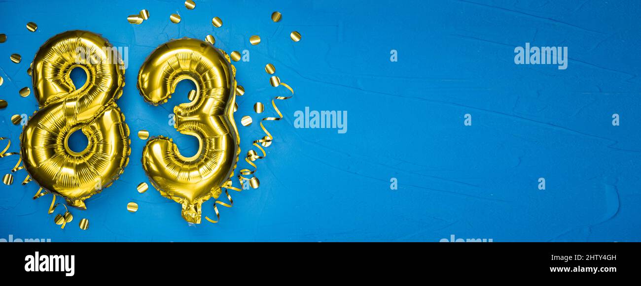 golden yellow foil balloon on blue concrete background number eighty ...