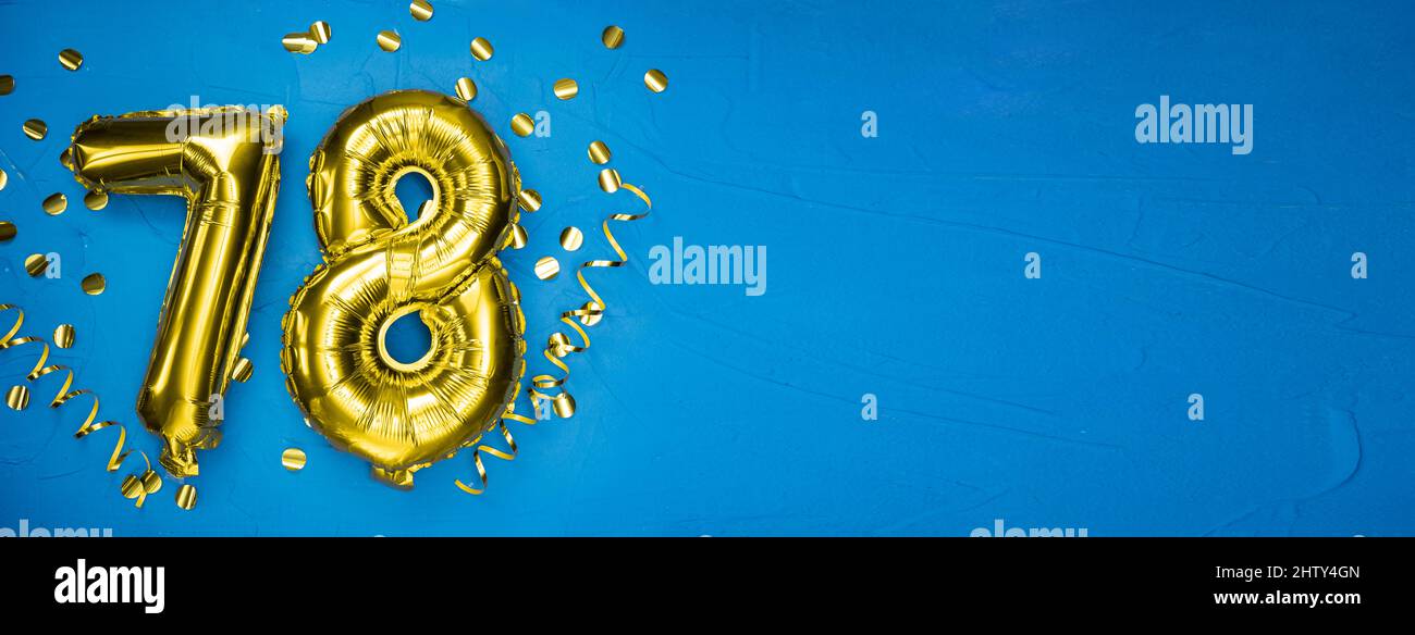 golden yellow foil balloon on blue concrete background number seventy ...