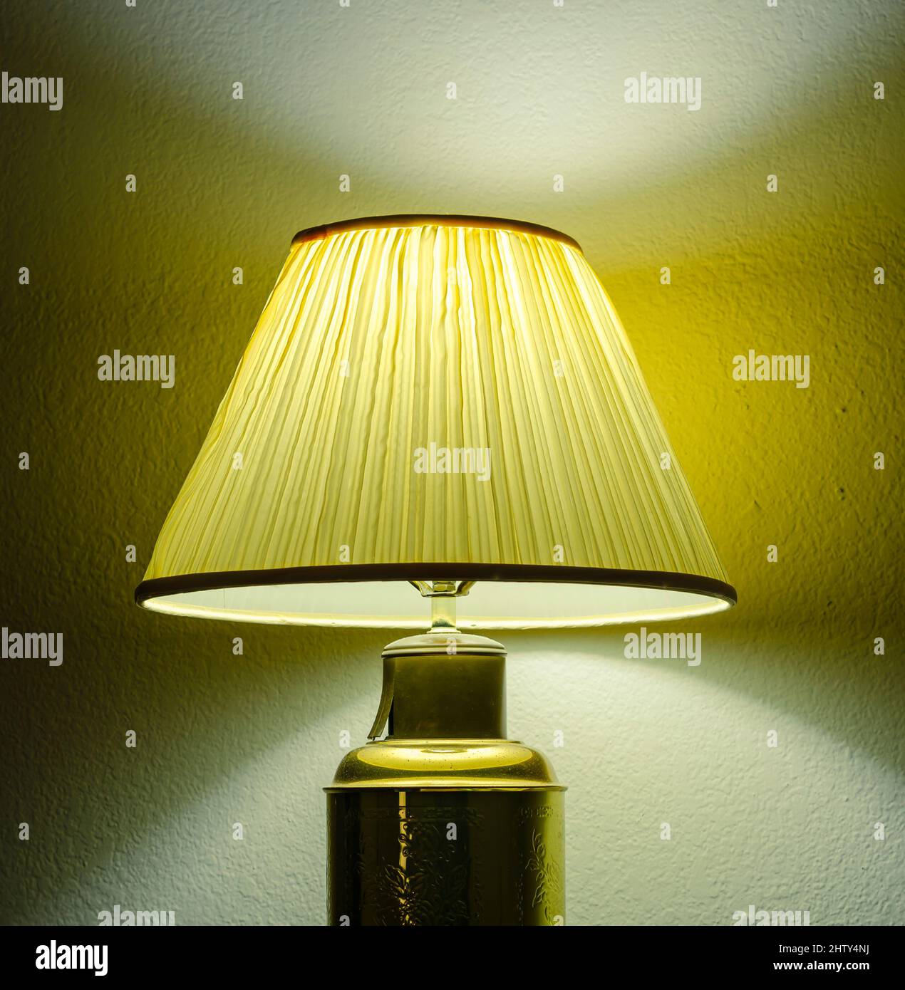 A lit lamp with a glowing lampshade casting a warm glow on the ...