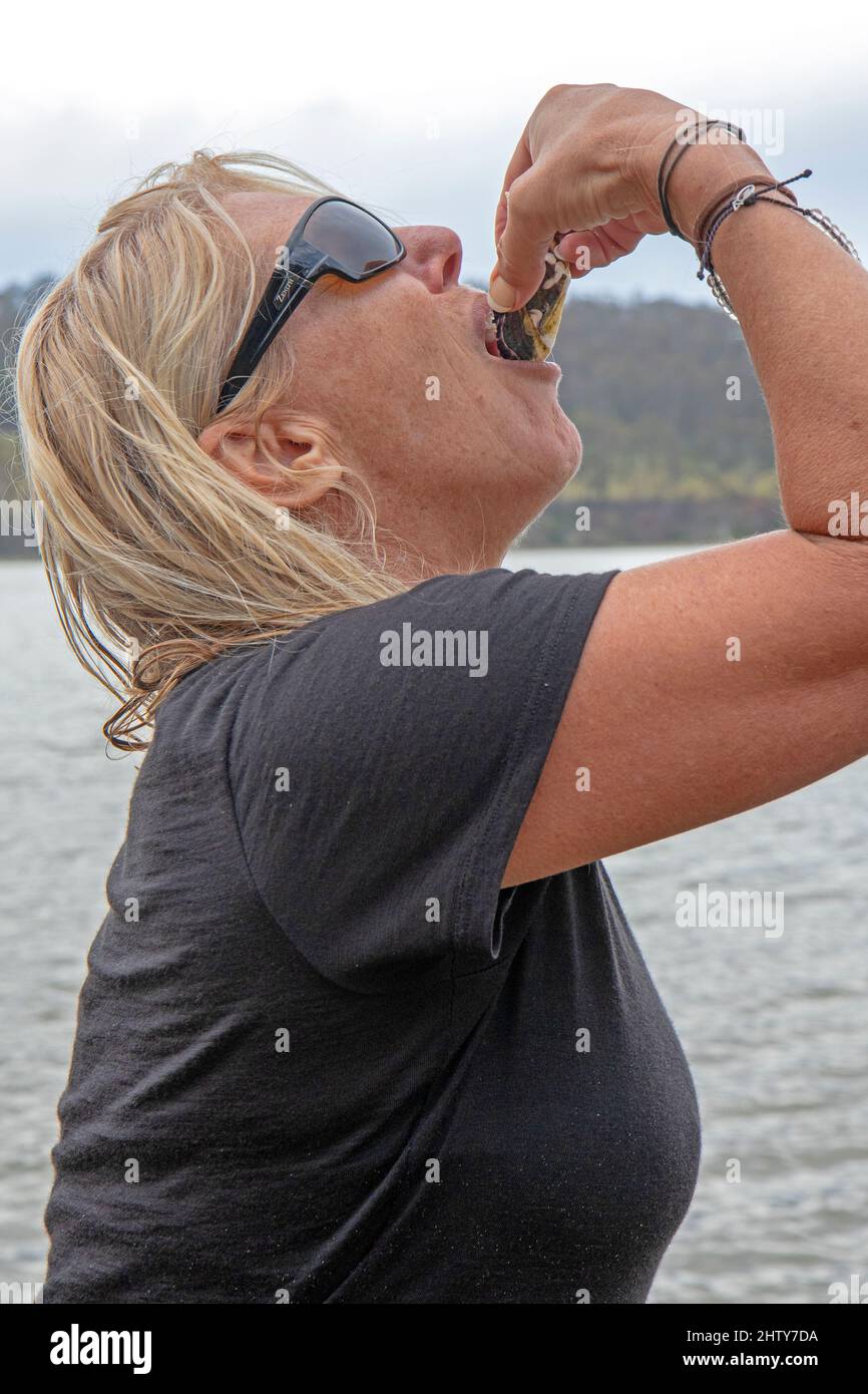 Woman eating an oyster Stock Photo - Alamy