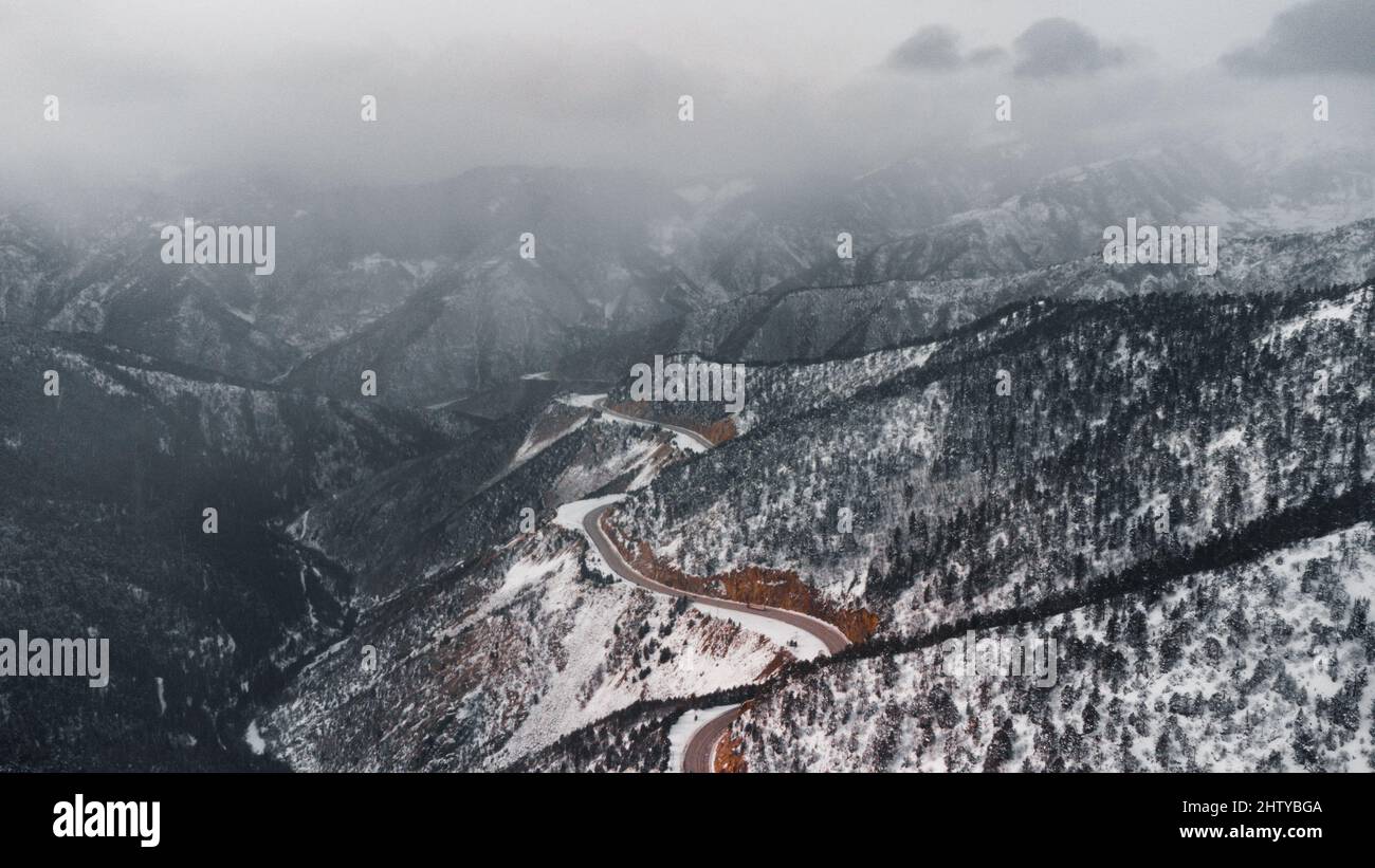 Aerial view of a long driving trail through snowy mountains Stock Photo ...