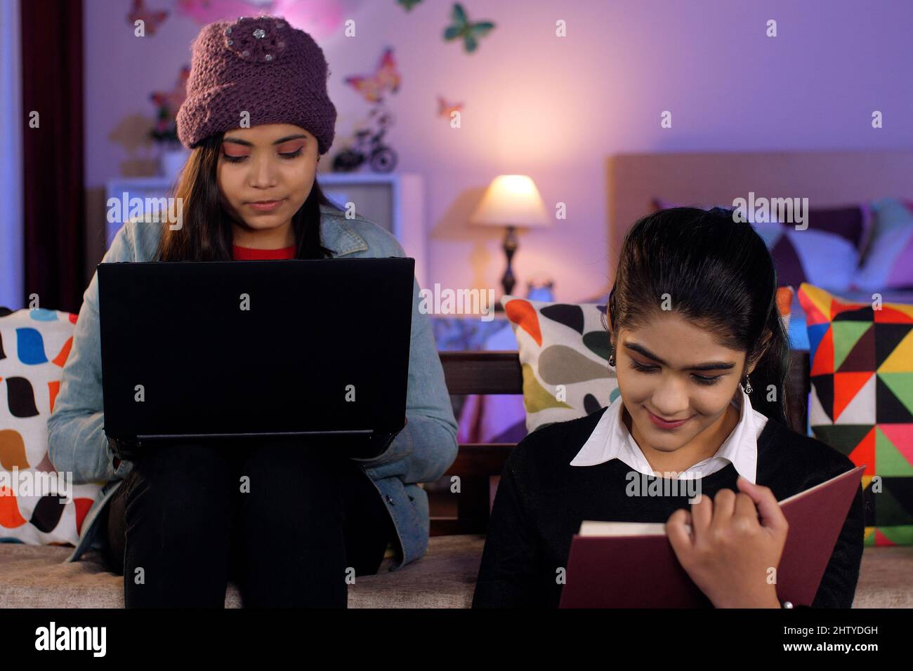 Young sisters, siblings enjoying me time. Two Indian girls busy in ...