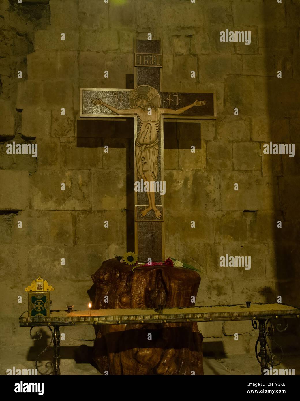 View of an ancient orthodox Crucifix in a dimly lit room in Georgia ...