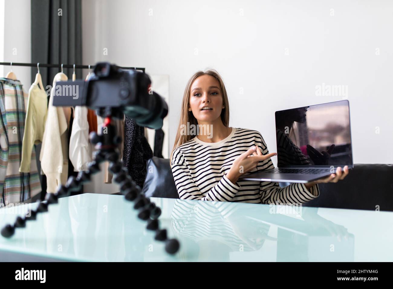 Female vlogger sitting beside desk with laptop, editing her video Stock ...